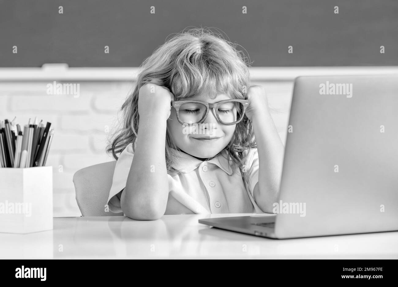 sleepy child boy in glasses study online in school classrrom with ...