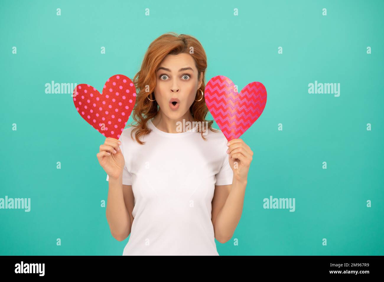 shocked young lady with red heart on blue background Stock Photo - Alamy