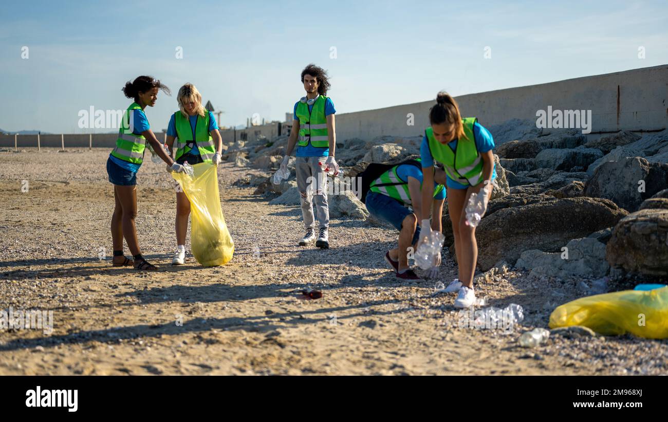 People cleaning up the beach, volunteers collecting the waste on the ...