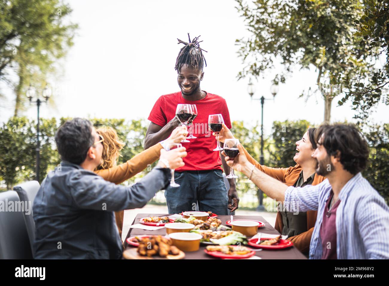 Happy family cheering with red wine at barbecue lunch outdoor ...