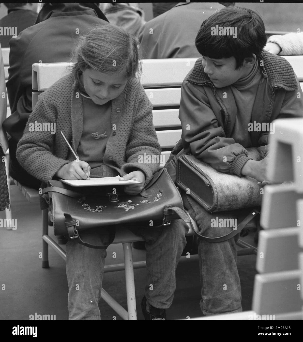 School children sitting on bench Black and White Stock Photos & Images ...