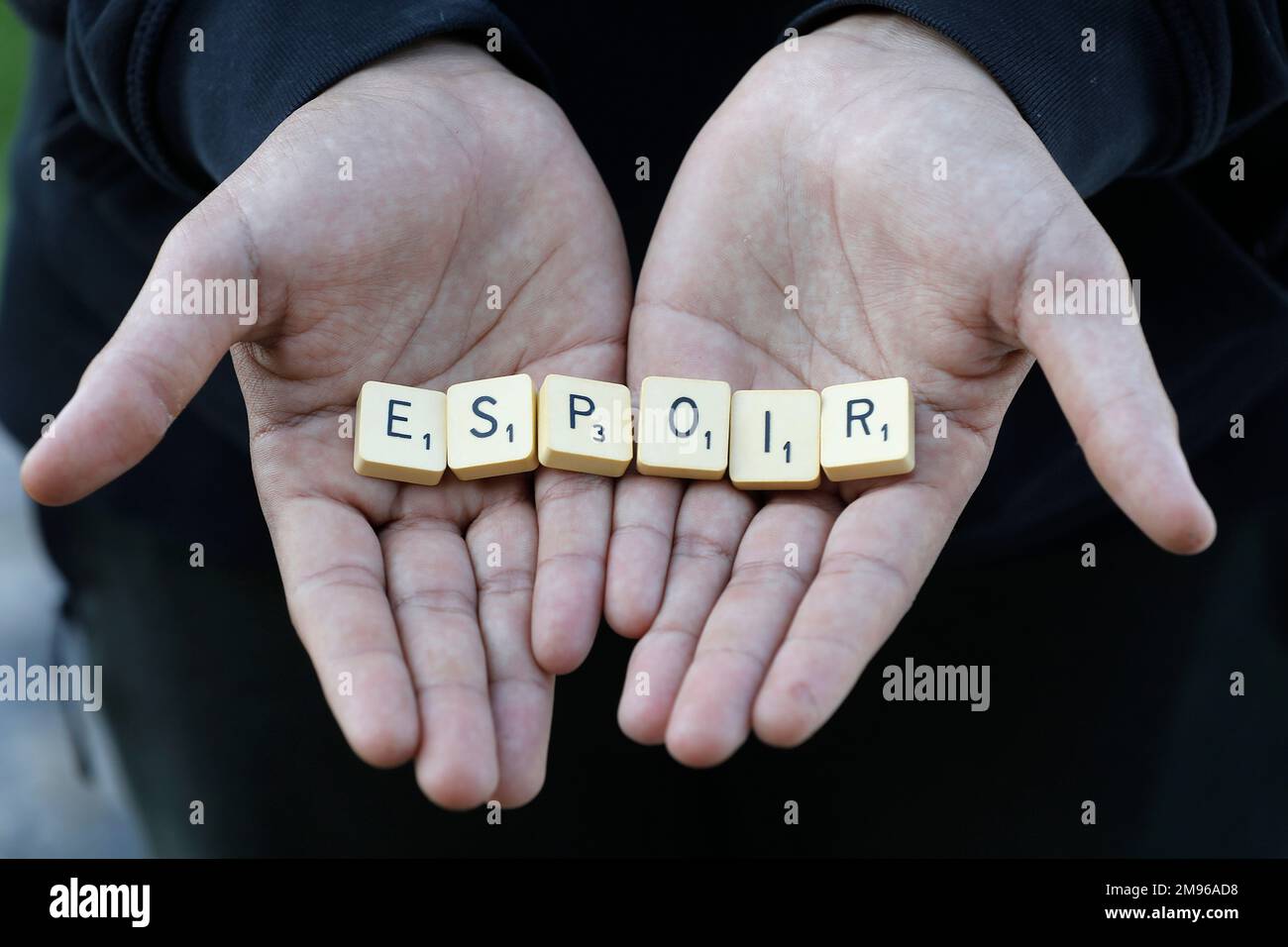 Boy showing letters spelling espoir (hope) in Eure, France Stock Photo ...