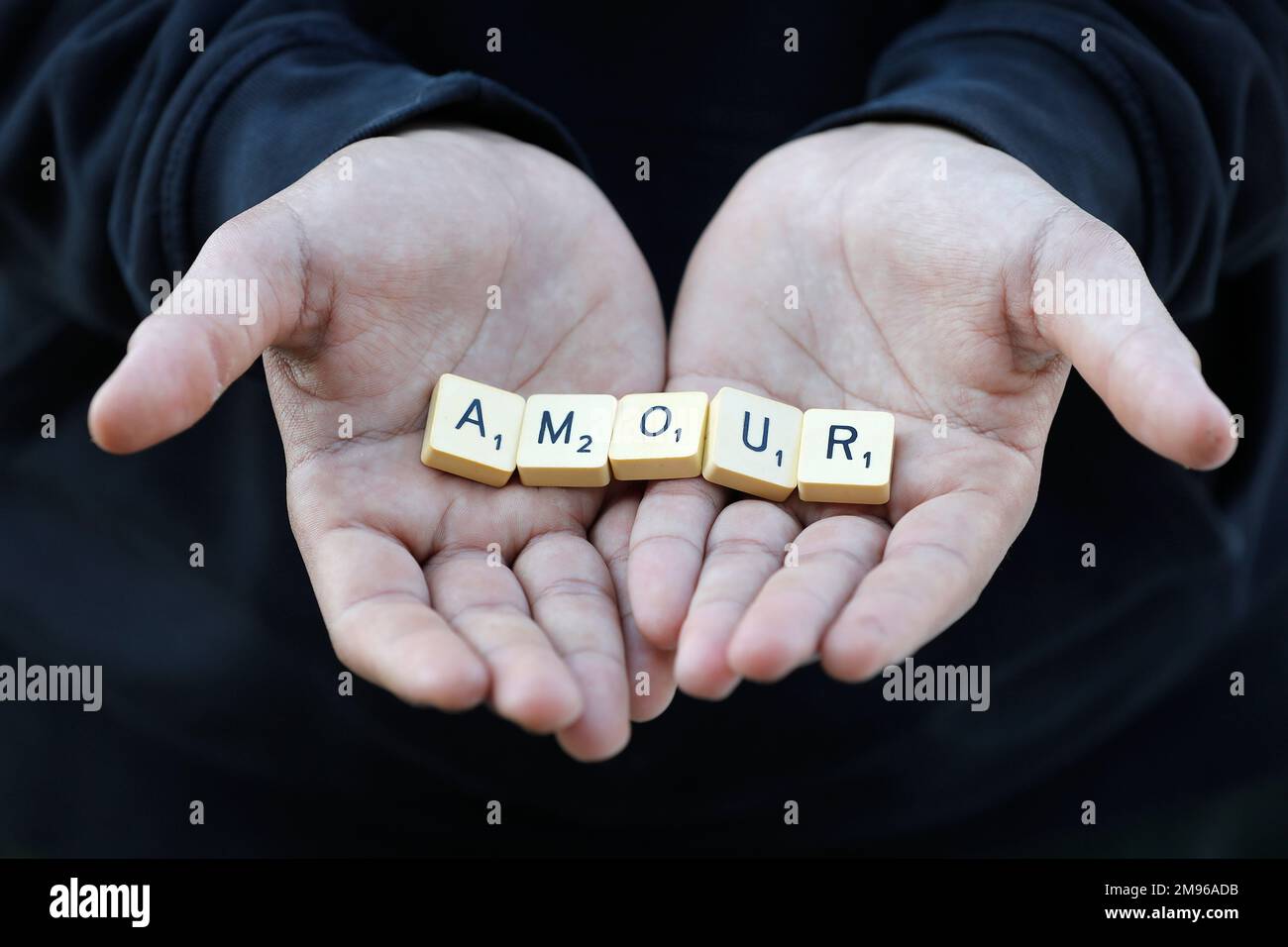 Boy showing letters spelling amour (love) in Eure, France Stock Photo ...