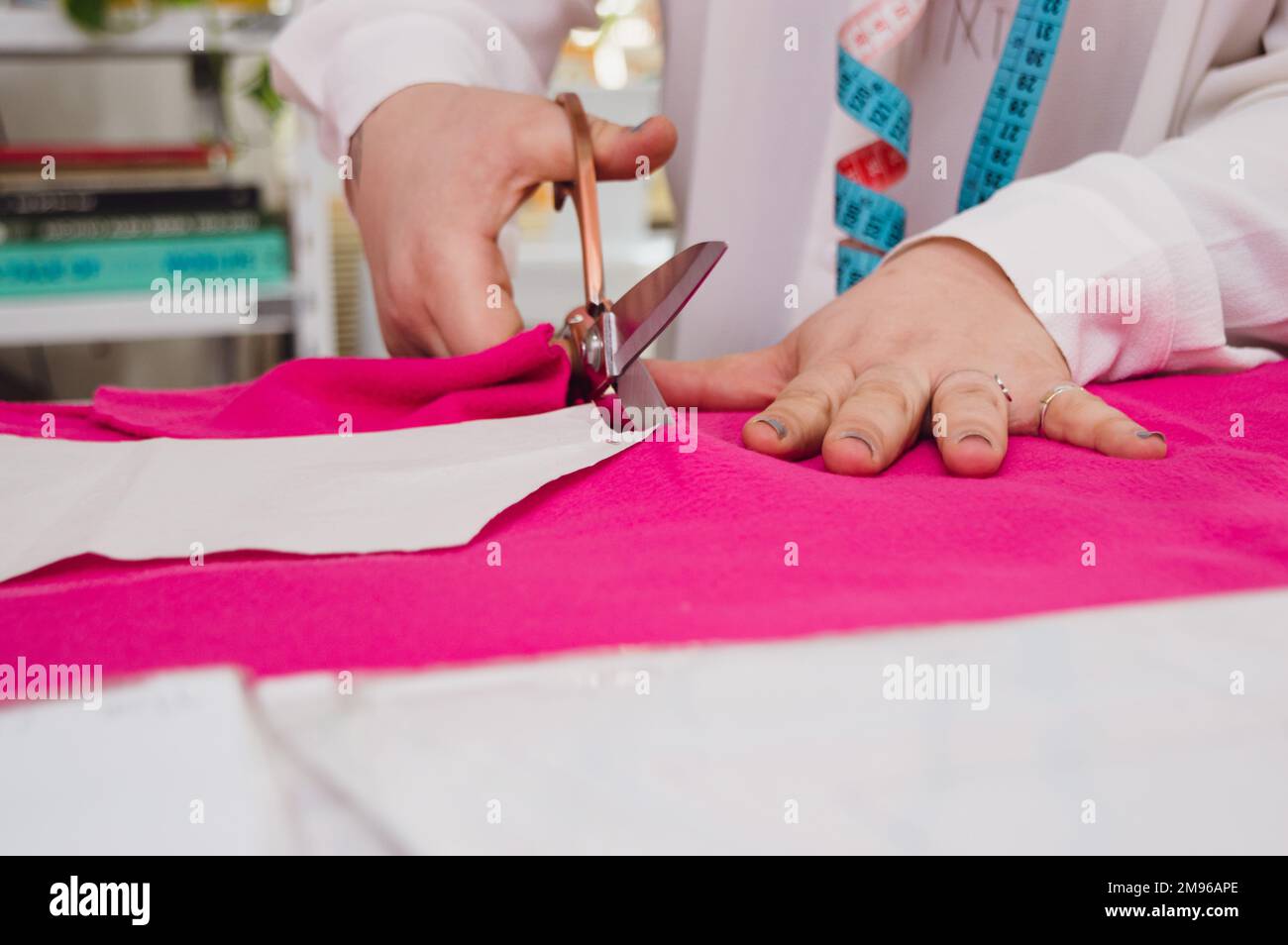 close-up of caucasian female hands cutting fabric with scissors on a ...