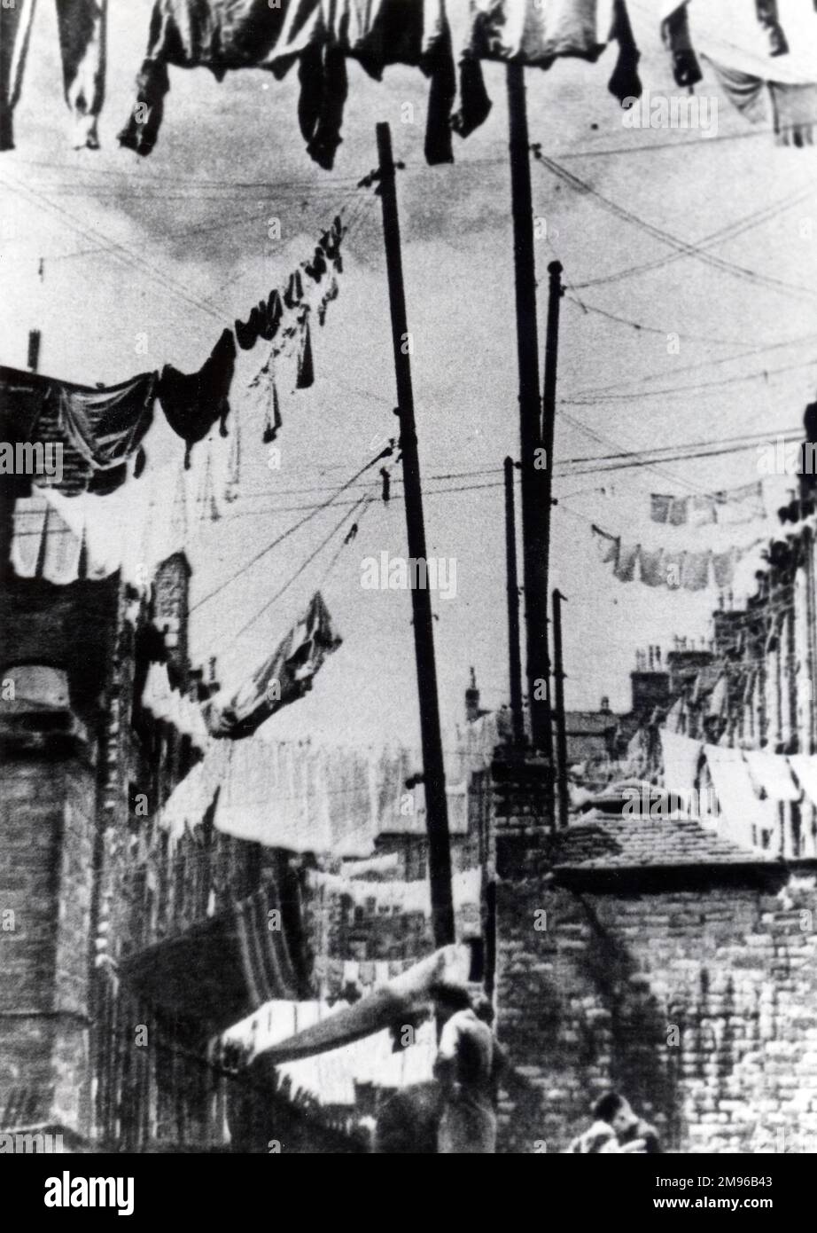 Numerous washing lines with clothes hanging out to dry at the back of ...