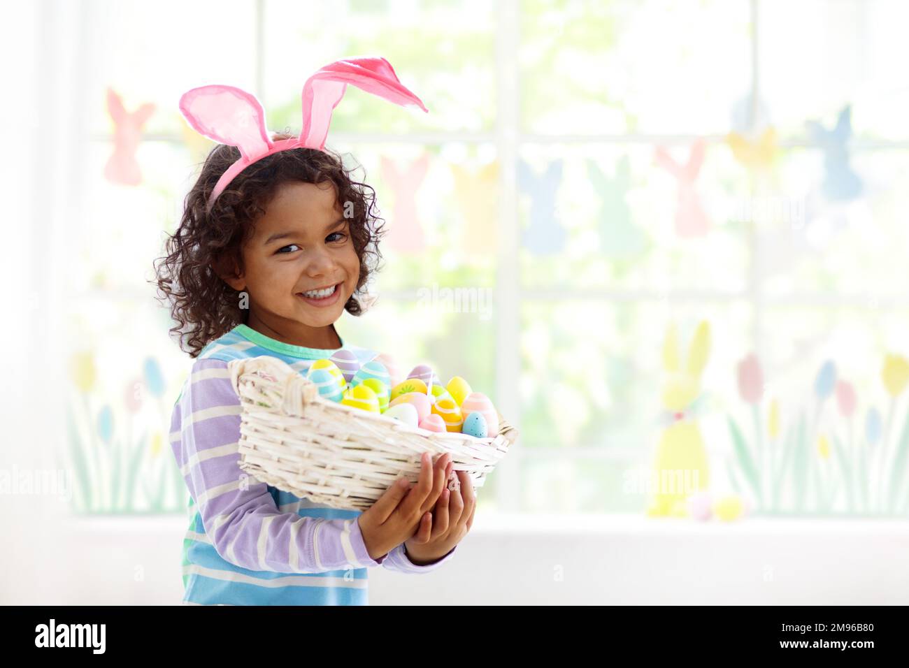 Kids dyeing Easter eggs. Children in bunny ears dye colorful egg for ...
