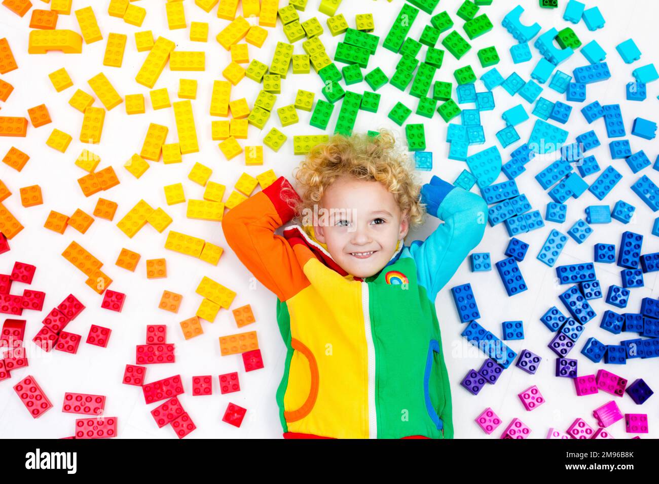 Funny little boy playing with colorful rainbow plastic blocks. Kids ...