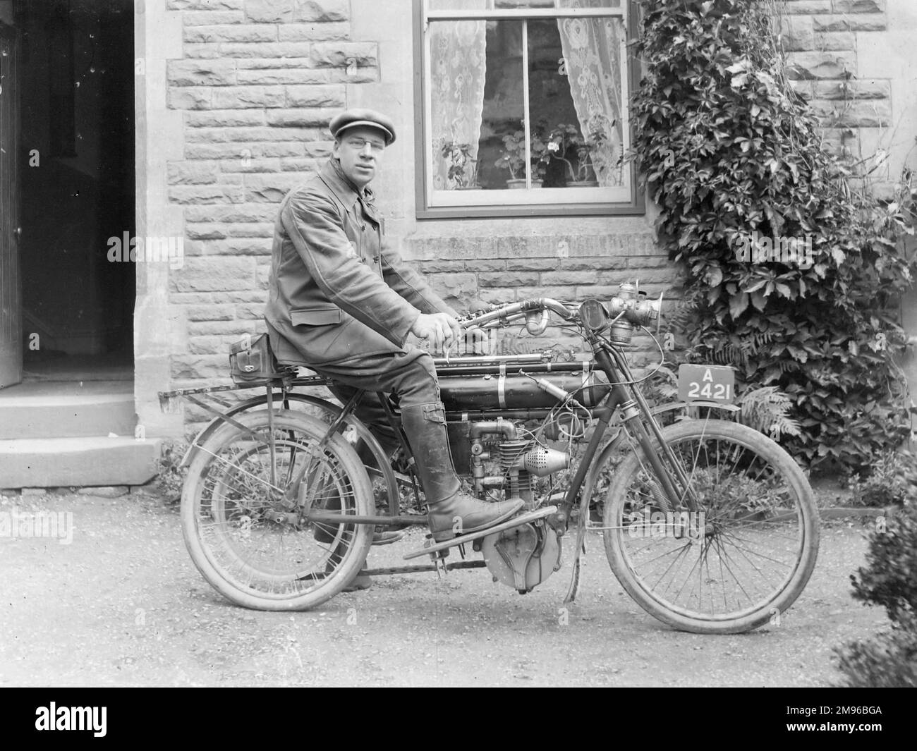 A man on an early motorcycle, possibly a Triumph, registration A 2421 ...