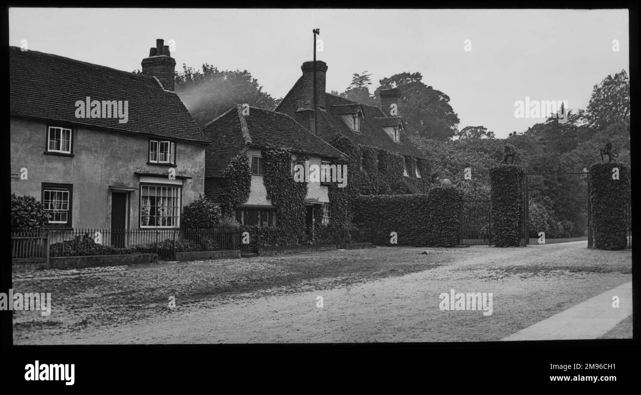 A row of cottage-style houses approaching a grand-looking gateway Stock ...