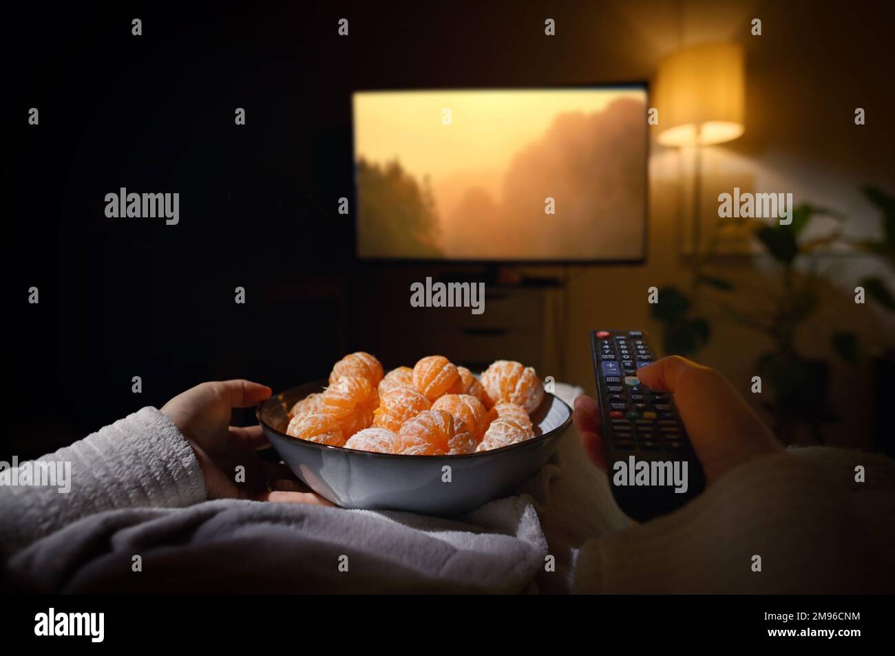 Relaxed Girl Watching Tv Holding Peeled Citrus Fruits and Remote ...