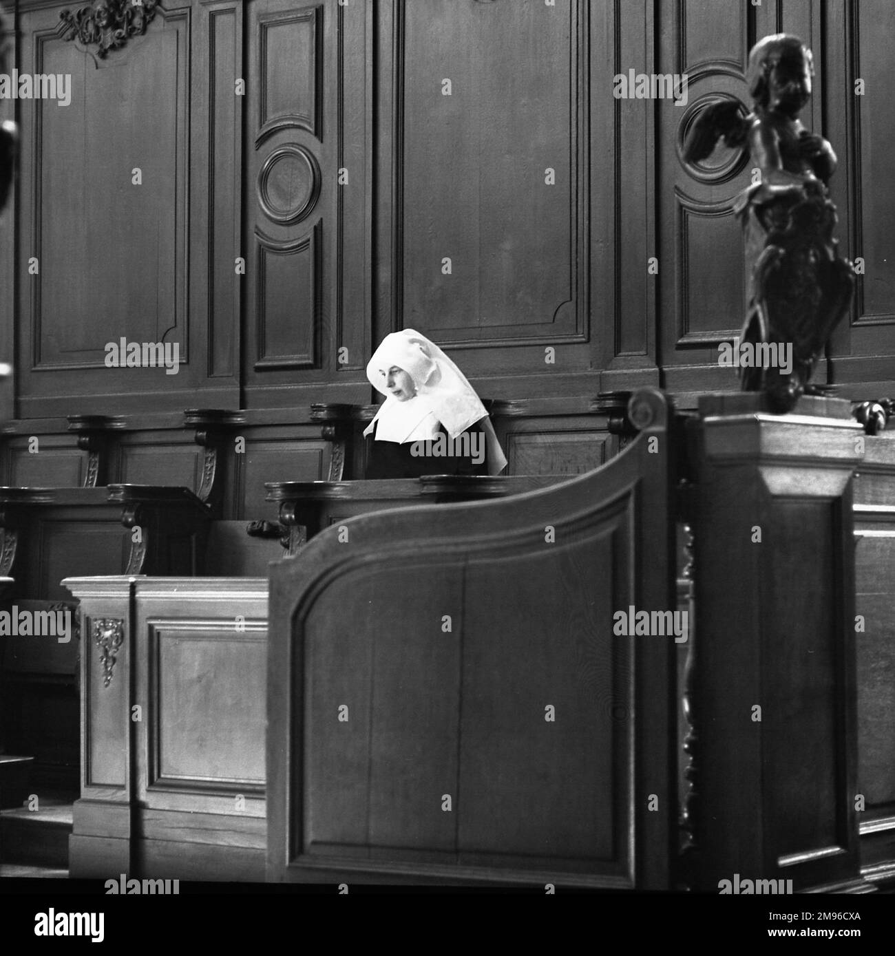 A nun sitting in a church pew Stock Photo - Alamy
