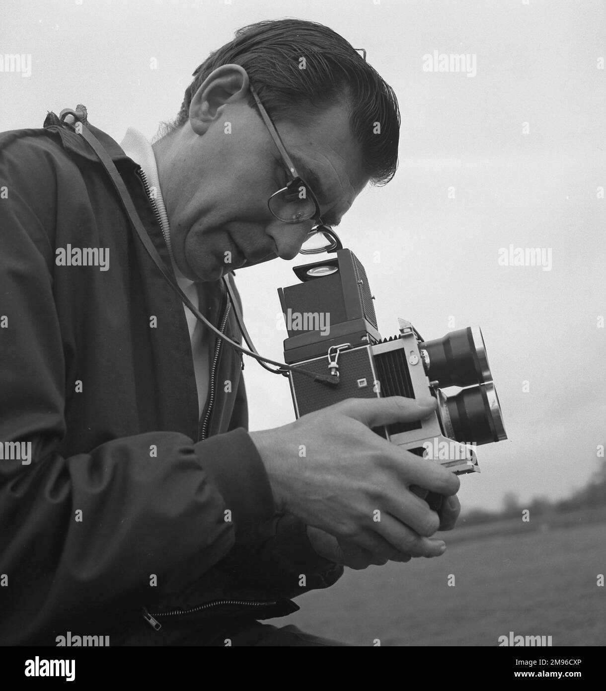 A photographer looks through the viewfinder of his camera Stock Photo ...