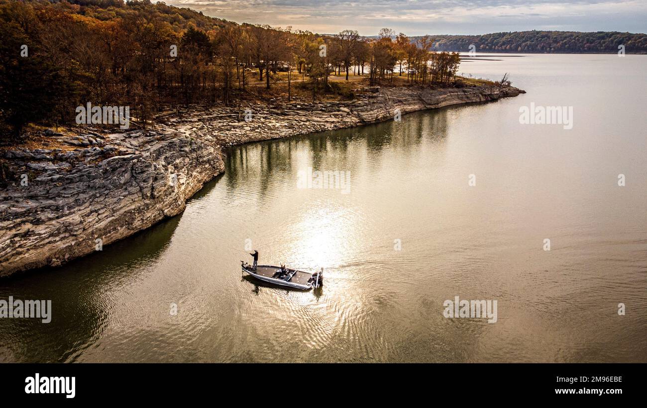 A bass fisherman fishing in the fall on lake Tenkiller in Oklahoma ...