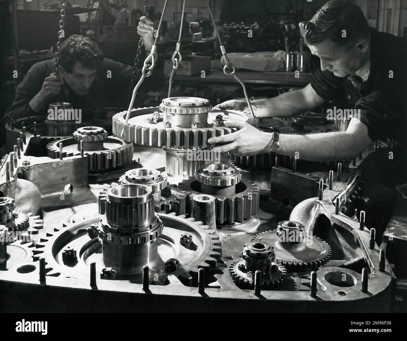 Two fitters assemble the large output pinion into the phasing gear case ...