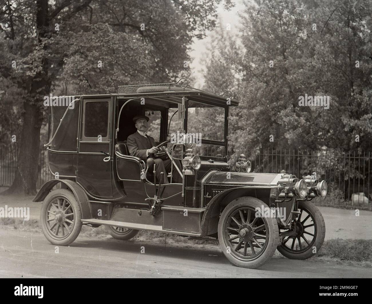 A man at the wheel of a rather smart-looking early car Stock Photo - Alamy
