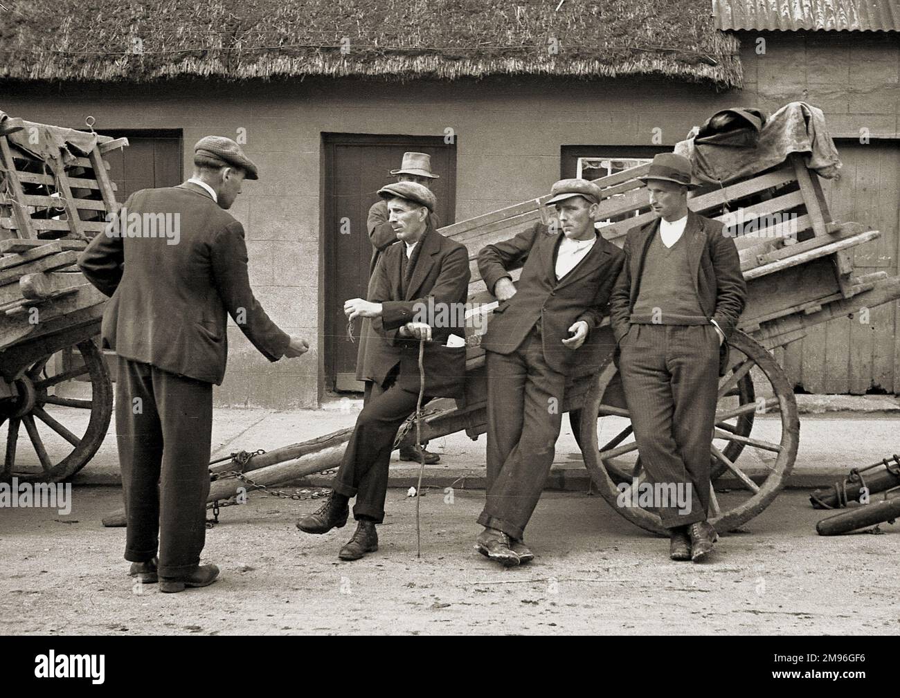 Men resting at the side of a cart Stock Photo - Alamy