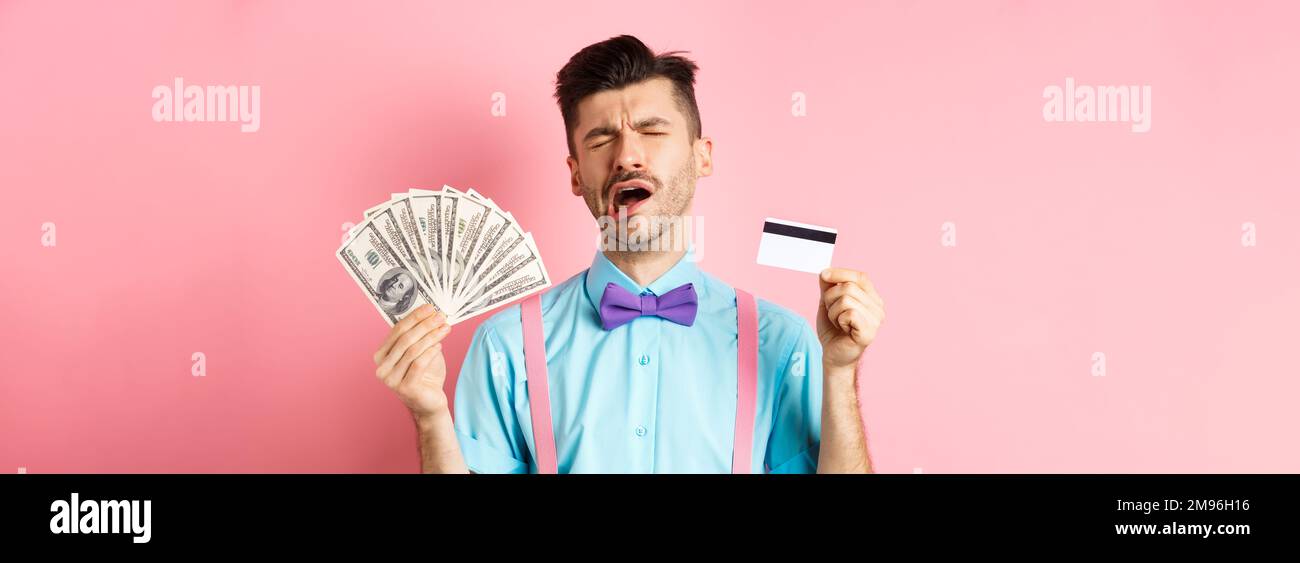 Sad crying man looking miserable, showing plastic credit card and money ...