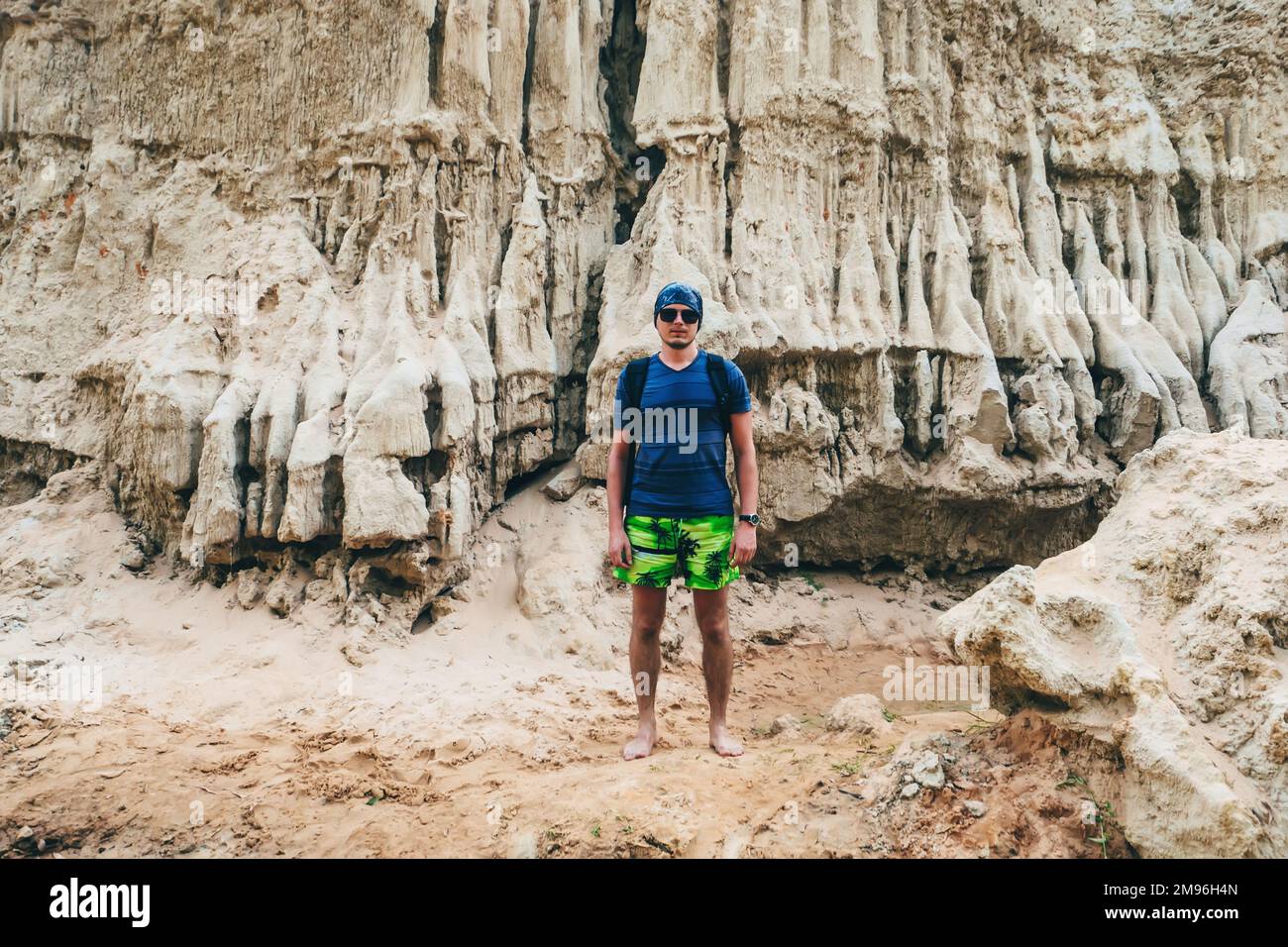 man tourist stands in the sandy rocks of the Fairy Steam in the Red ...