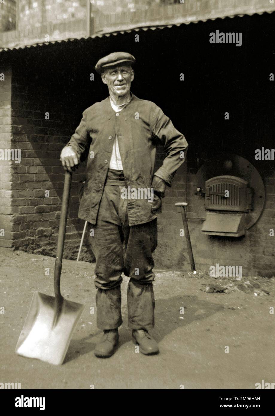 A middle-aged workman standing in a yard with a large spade Stock Photo ...