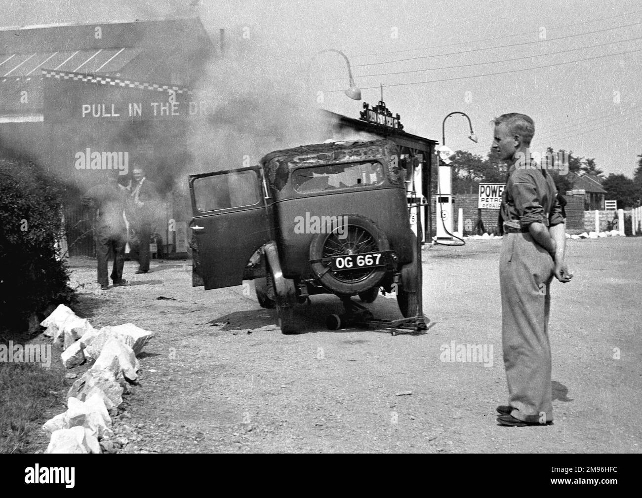 Scene outside a garage, with a burning car Stock Photo - Alamy