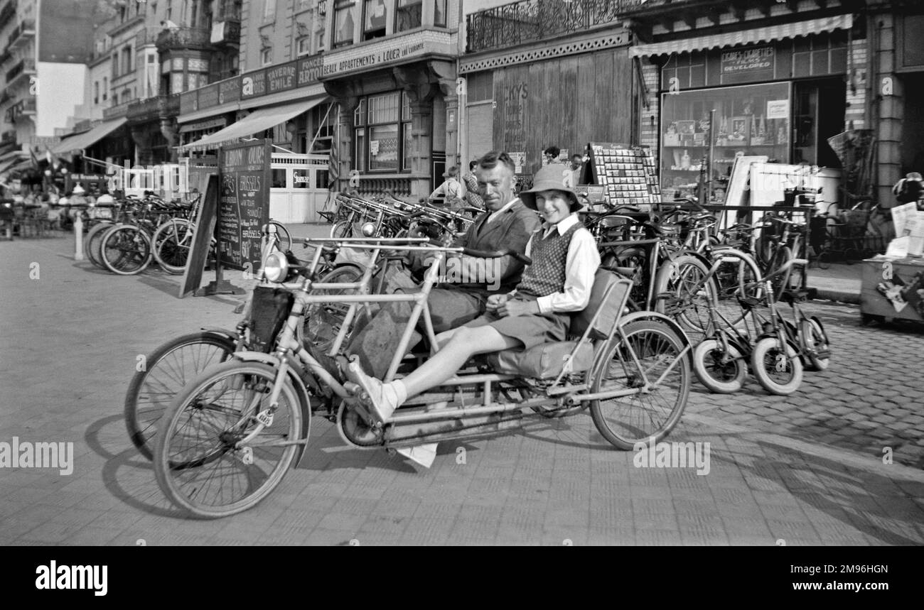 A couple on a four-wheeled two-seater cycle (also known as a velo ...