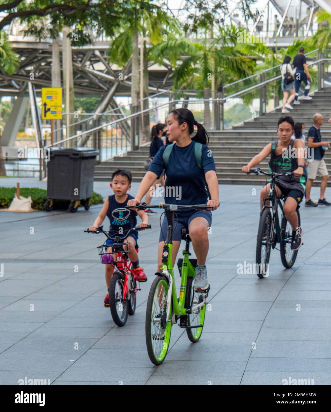 Girl and two boys riding a bike at Marina Bay Sands Singapore Stock Photo - Alamy