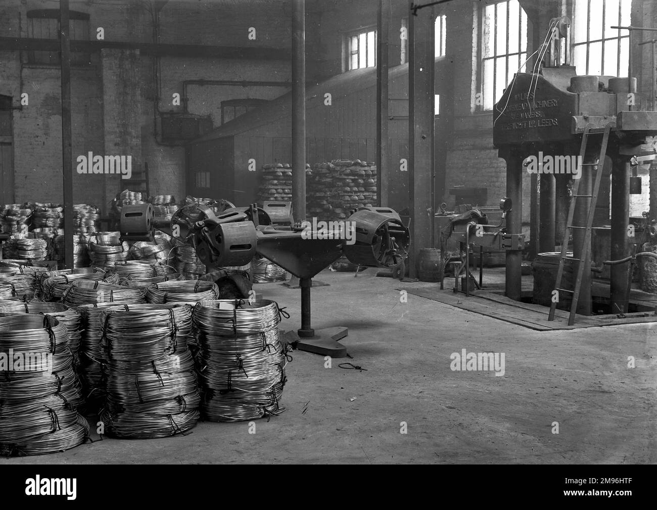 A factory with newly manufactured wire standing in coils on the floor ...