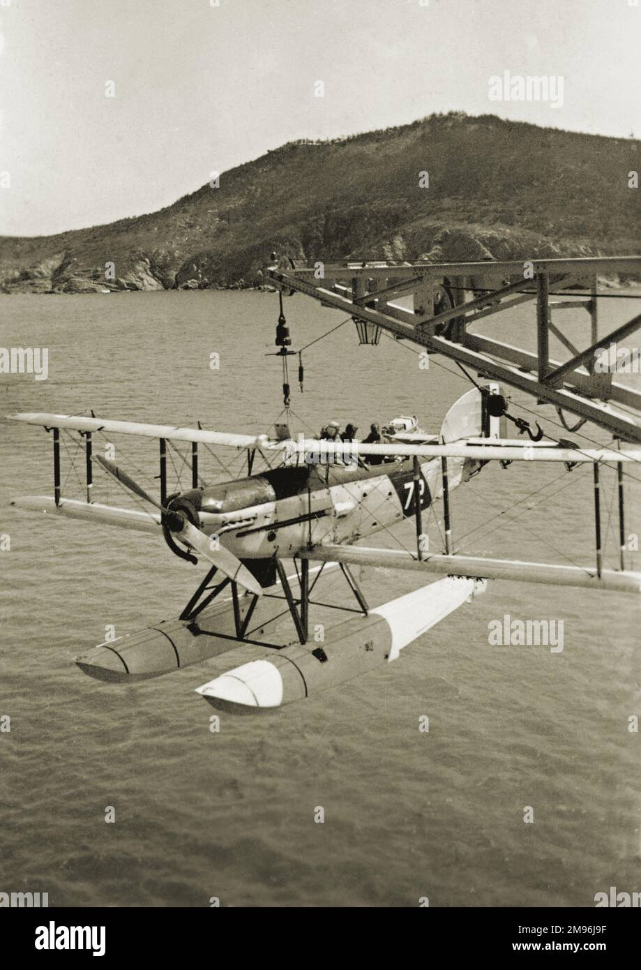 A seaplane hanging from a crane, with people inside it Stock Photo - Alamy