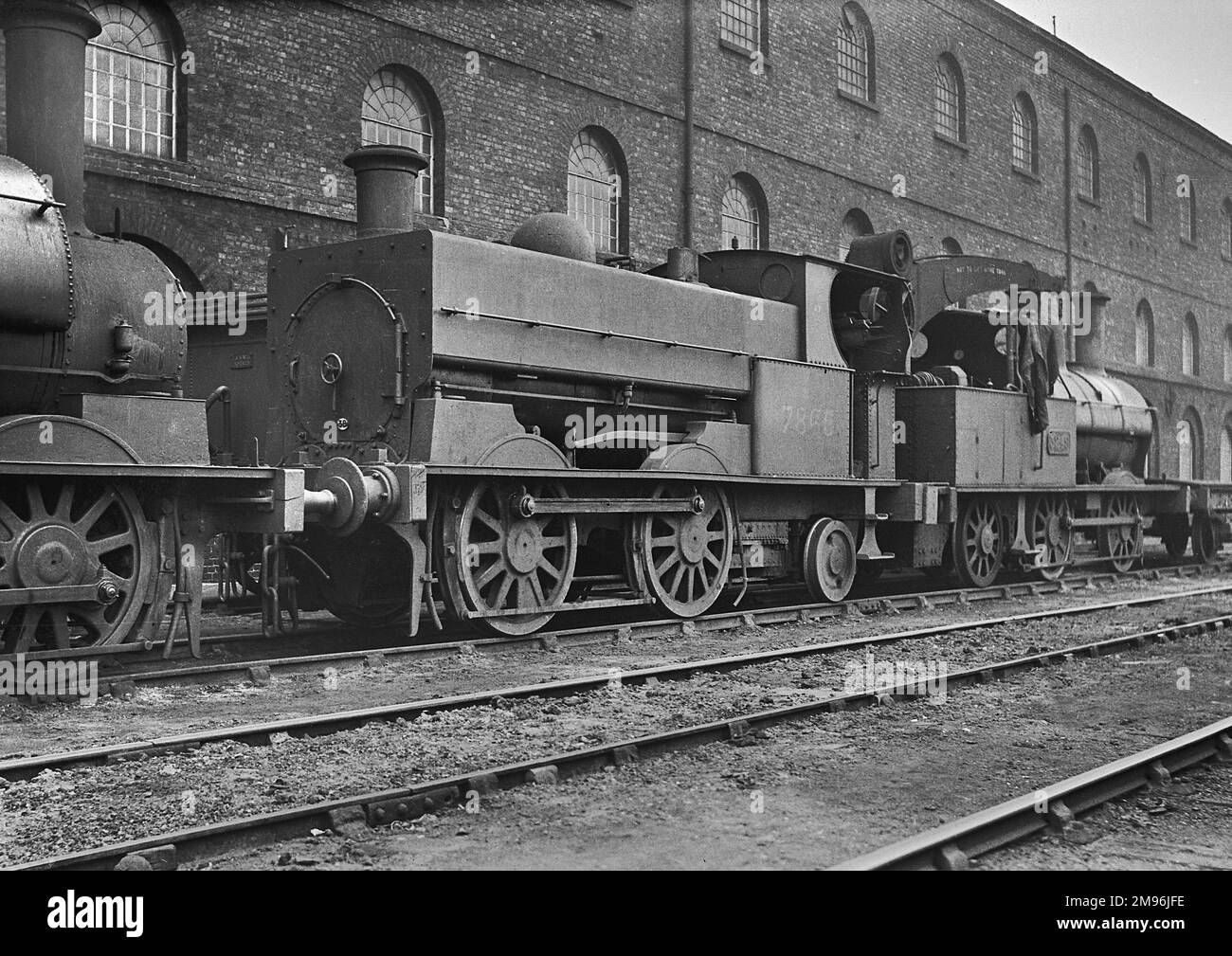 Steam engine with lifting equipment on a railway track at the side of a ...