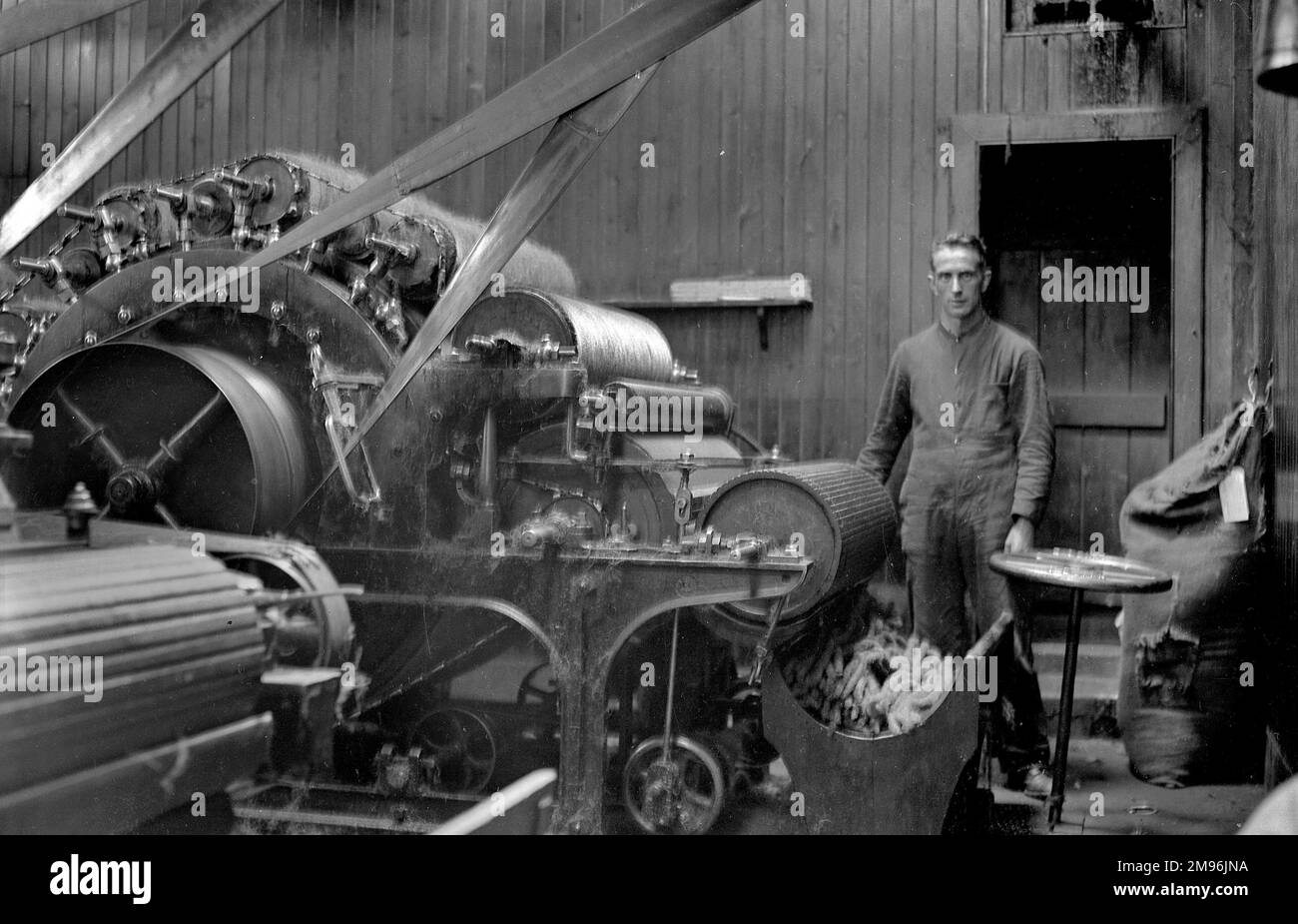 A man in the textile industry in Scotland, operating a machine with ...