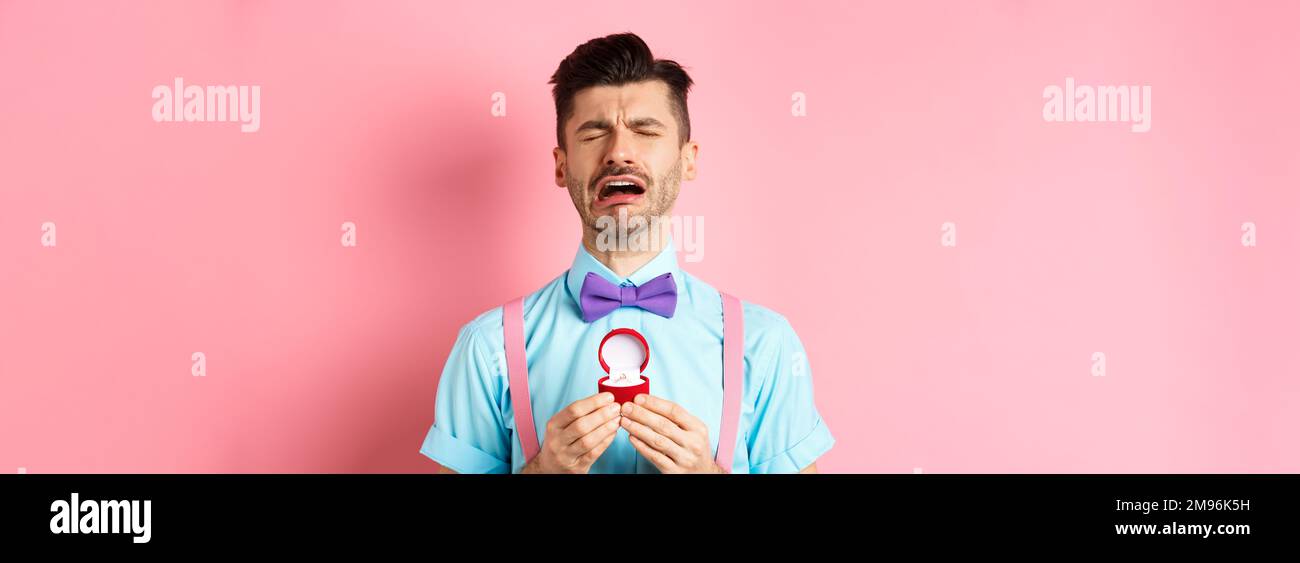 Valentines day. Heartbroken guy crying and holding engagement ring ...