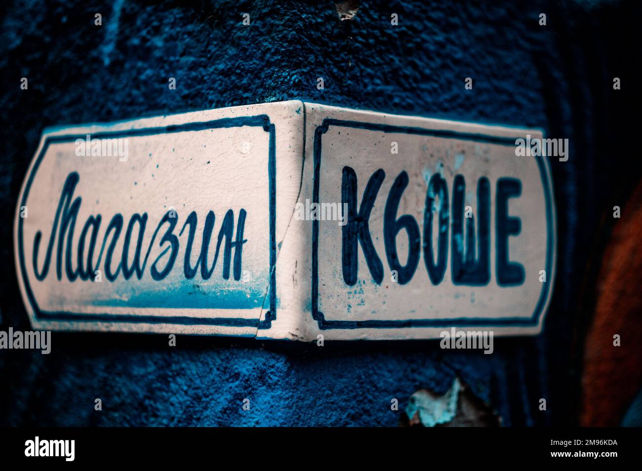 A closeup of a shop sign with Russian text on a blue wall Stock Photo ...