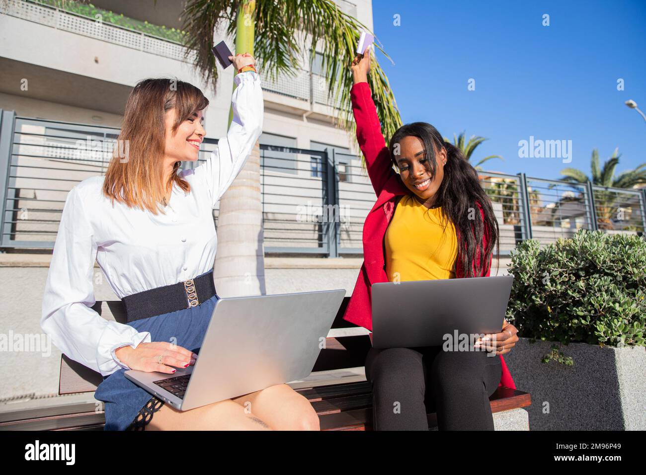 Two girls make online purchases with their credit cards and are happy ...
