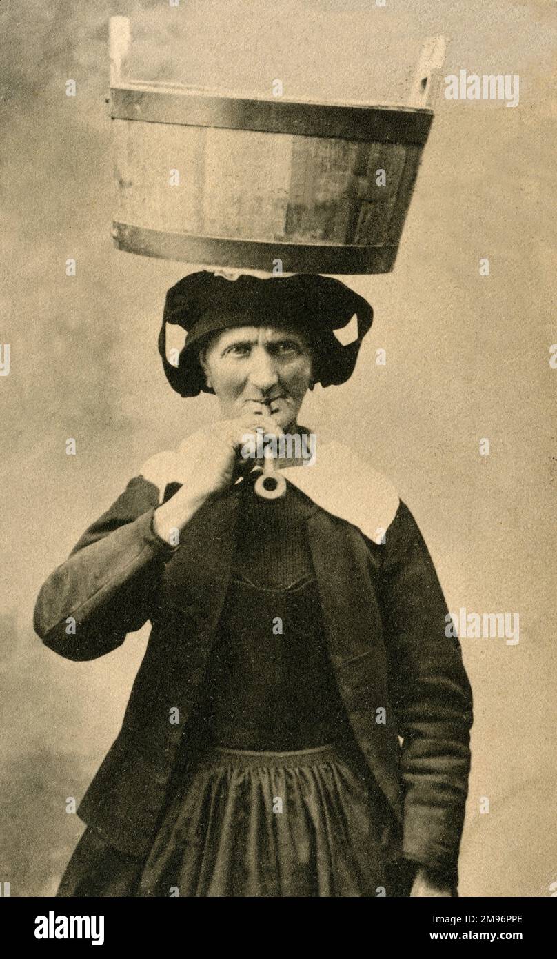 Elderly woman with a bucket on her head Stock Photo - Alamy