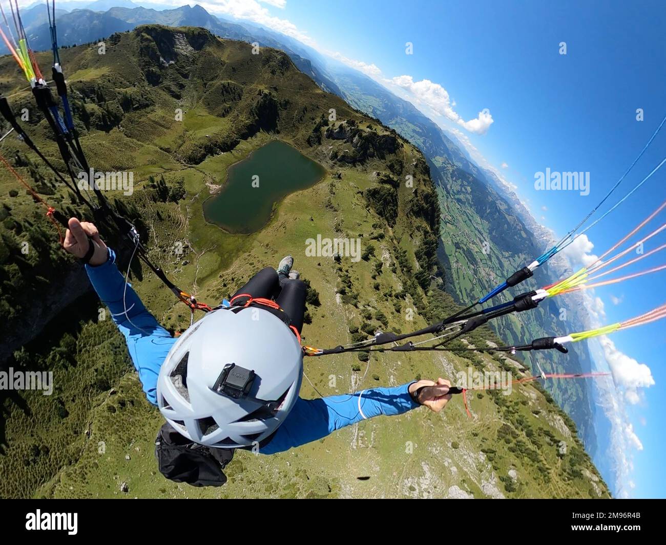 A top view of a skydiver paragliding on a scenic landscape with a ...