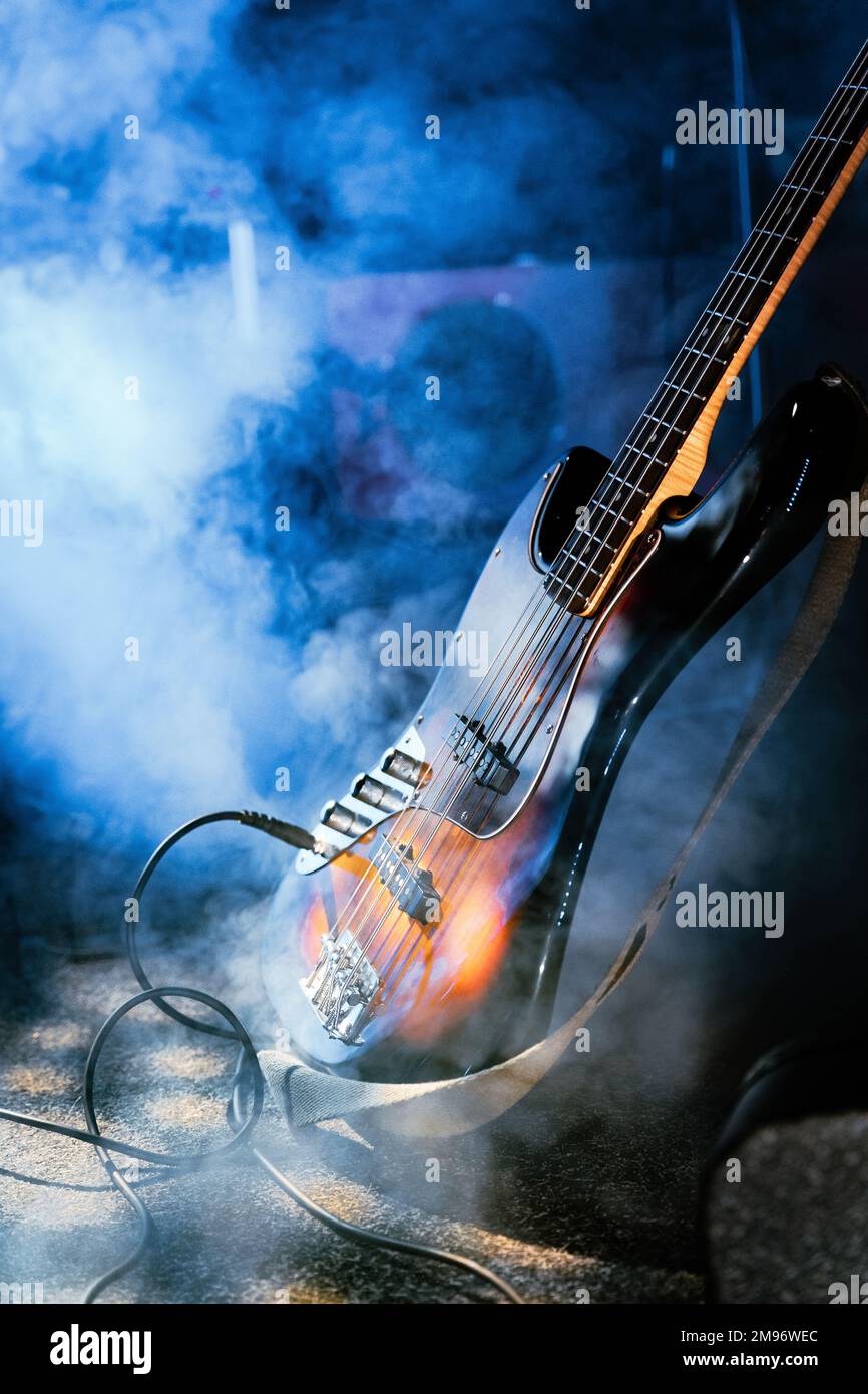 A vertical shot of a bass guitar on the stage with a fog machine Stock ...