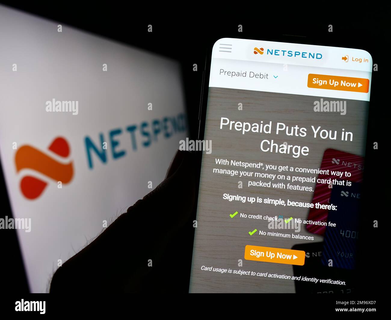 Person holding cellphone with webpage of US payments company Netspend ...