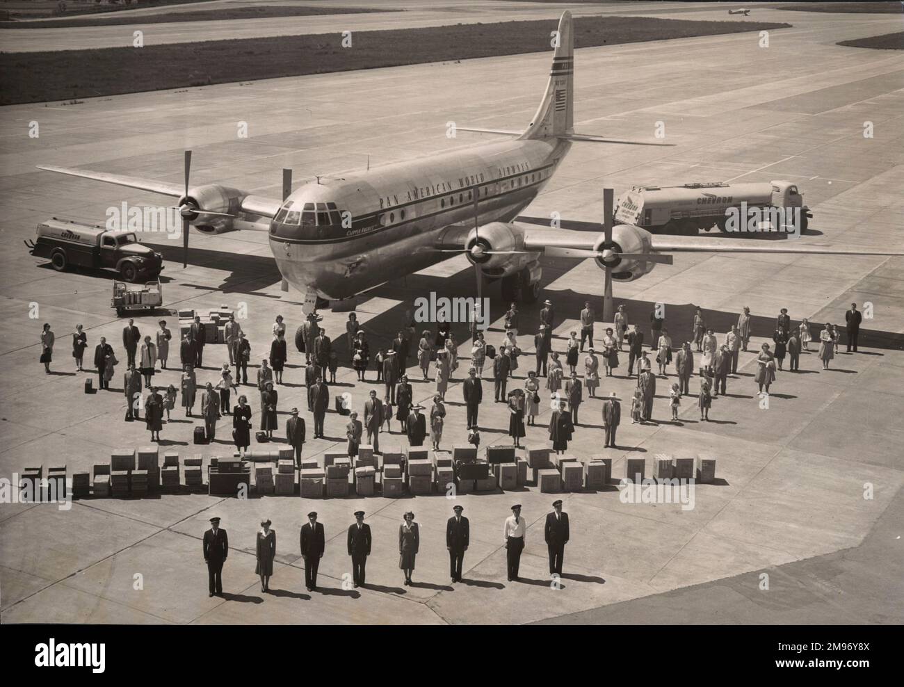 A Boeing 377 Stratocruiser of Pan American World Airways poses with its crew and passengers ...