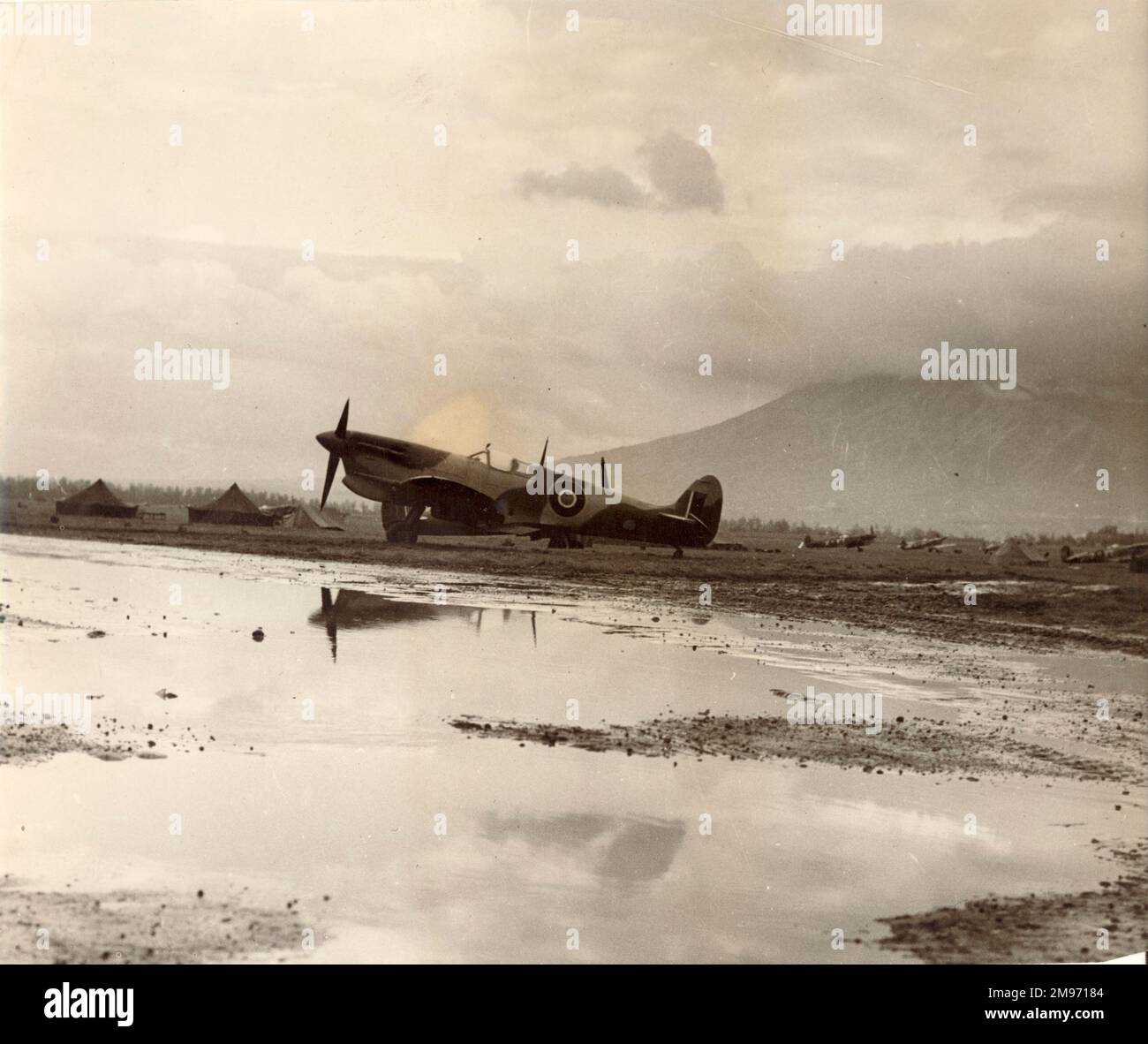 Supermarine Spitfire fitted with a tropical filter on a wet airfield in ...