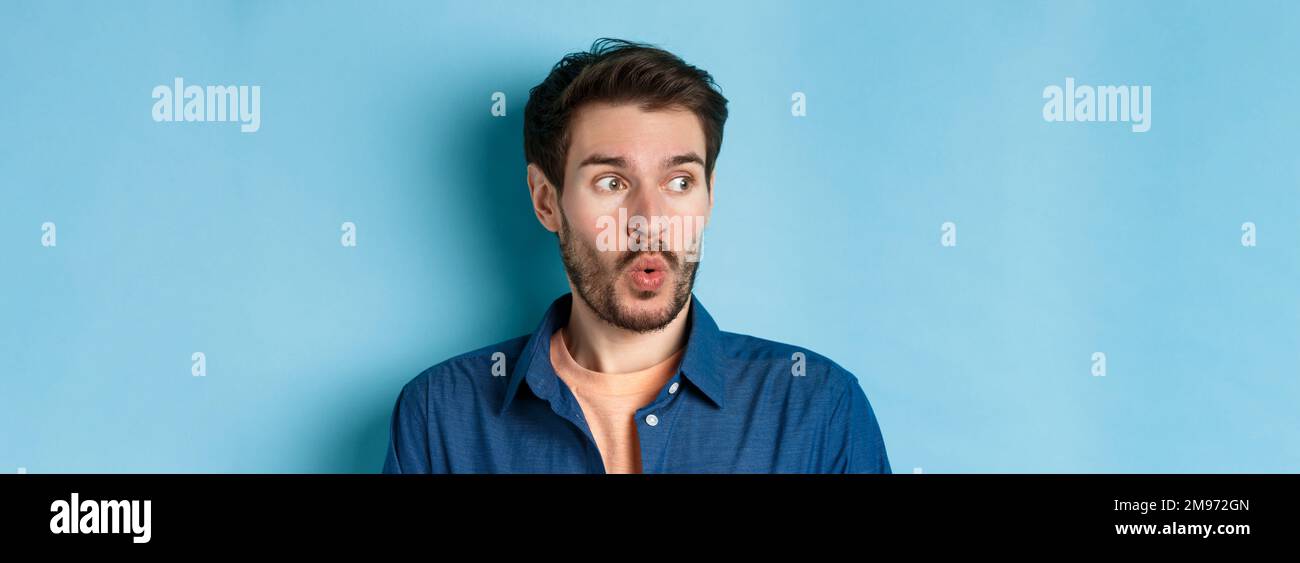 Close up of impressed man say wow and checking out banner, looking left ...