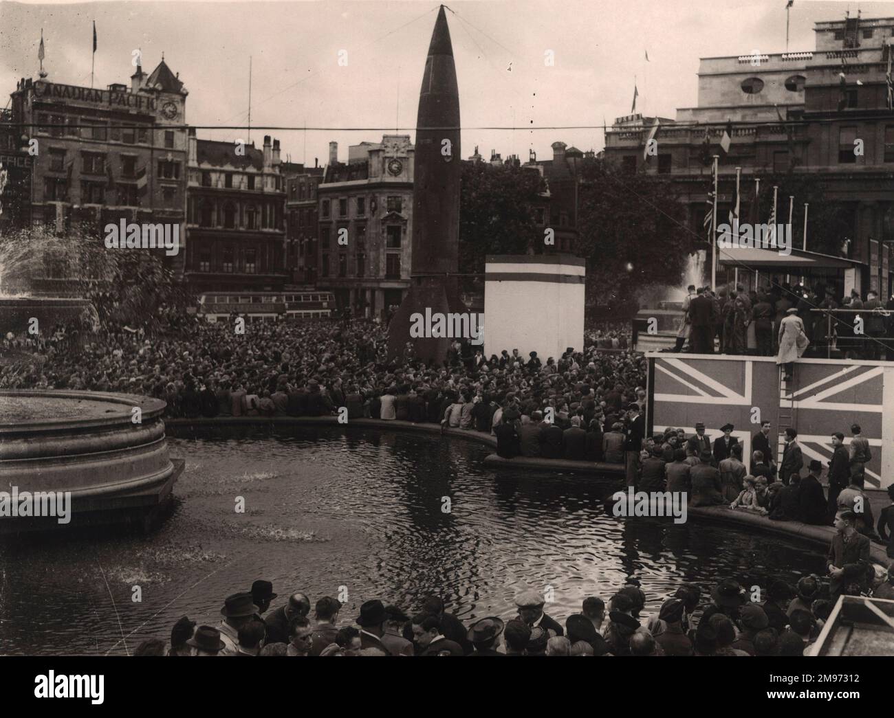 A V-2 on display in Trafalger Square with a crowd listening to a speech ...