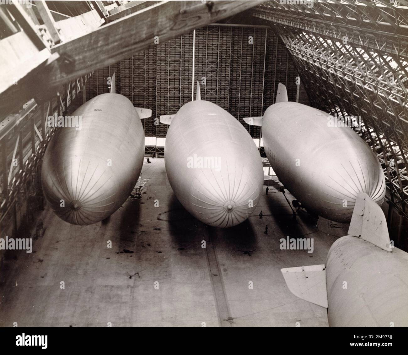 Four US Navy Goodyear K-Series airships in a hangar. This hangar is ...