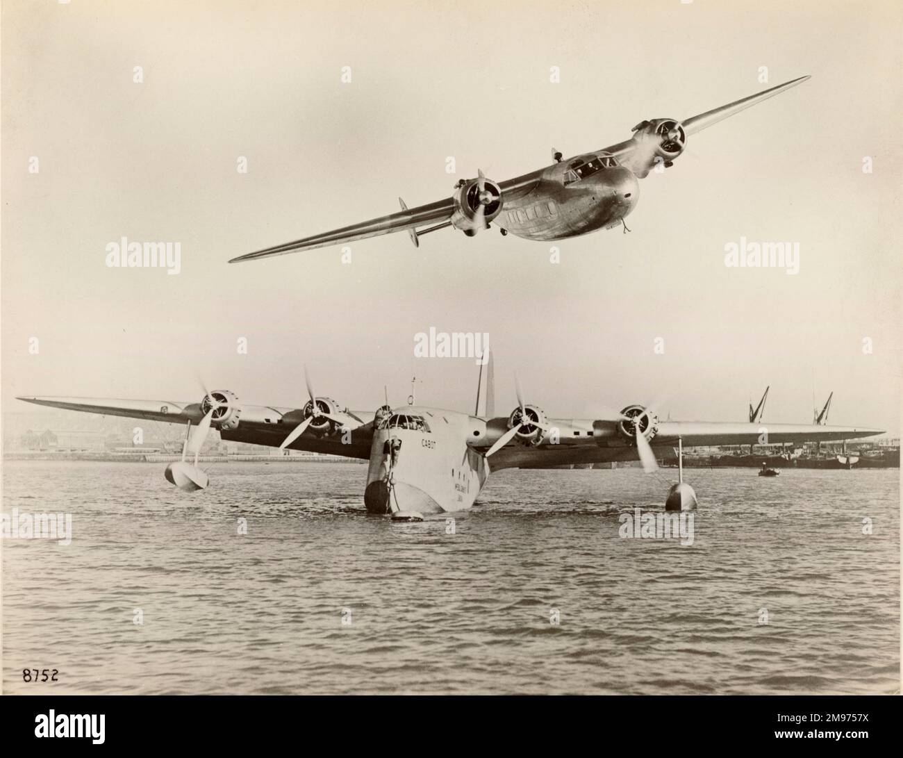Short S30 Empire Flying Boat, G-AFCU, Cabot, is overflown by a de ...