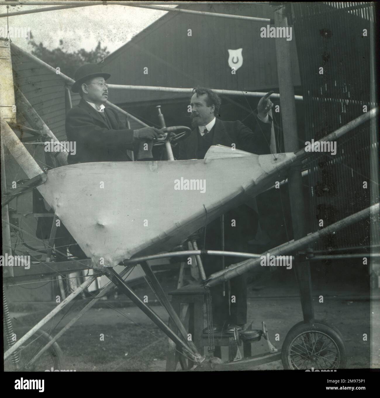 Samuel F. Cody shows the Military Trials Machine to a Japanese official ...