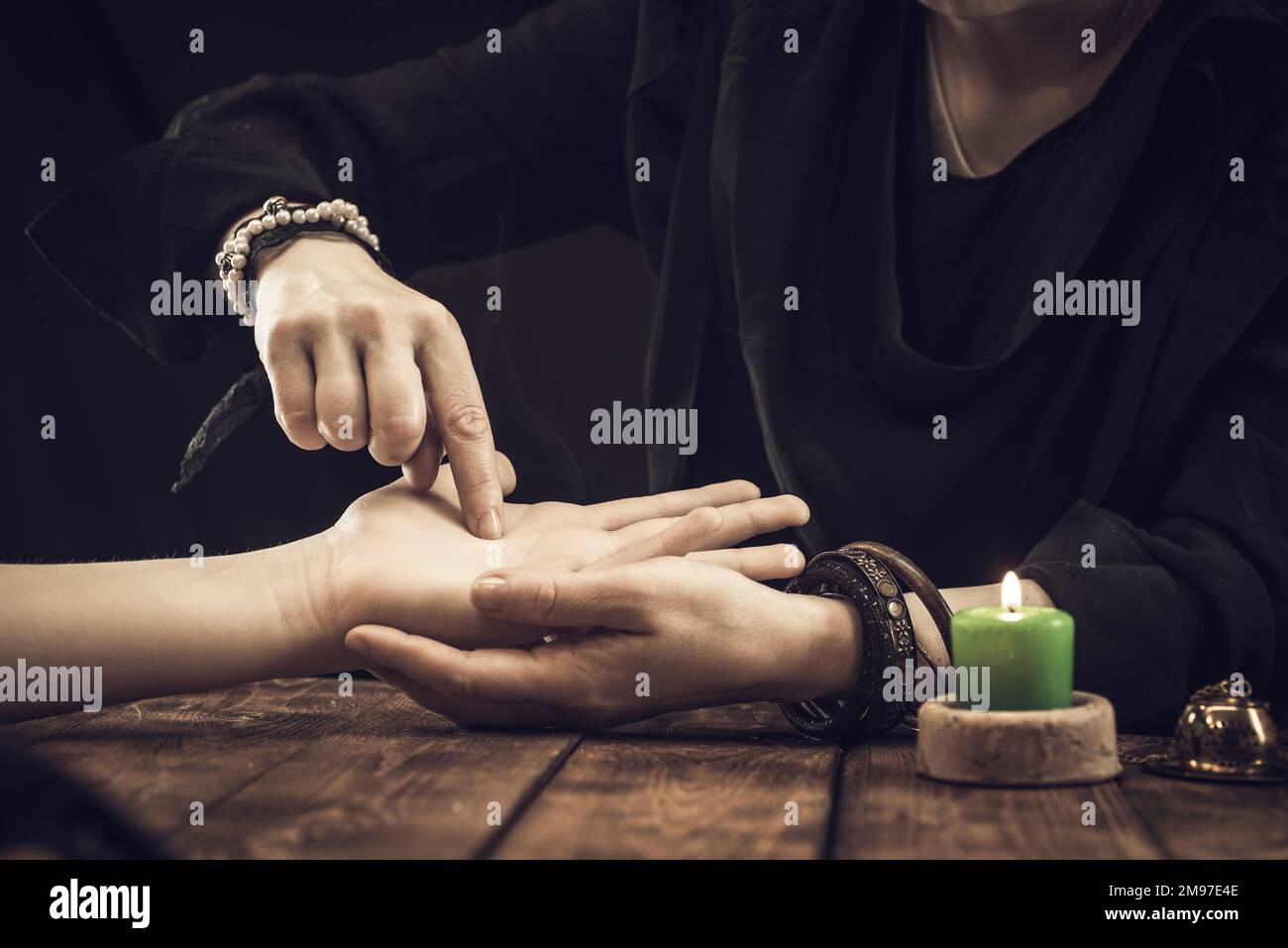 Fortune teller or oracle in search of the lines of fate in the palm of ...