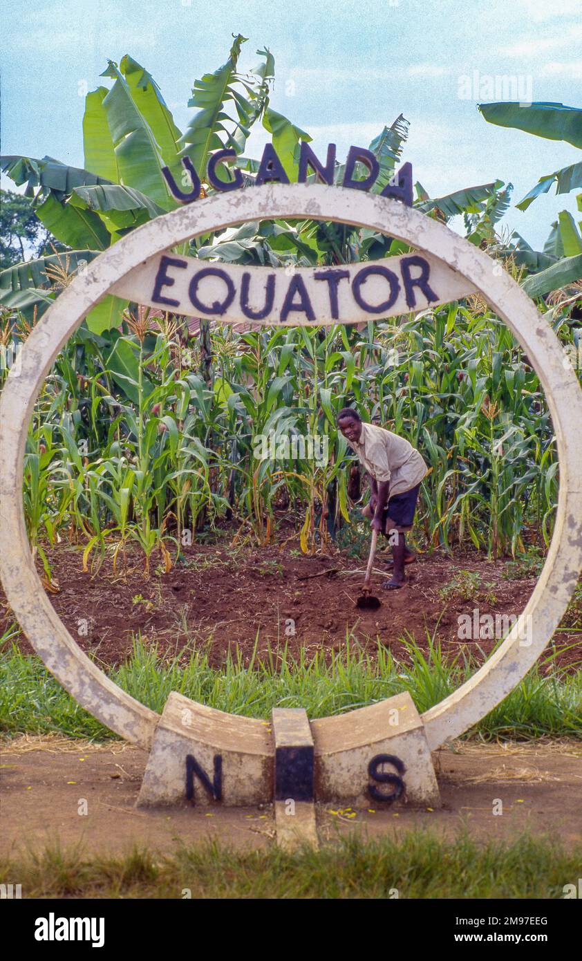 Uganda; A boy on a maize field ploughing the field behind the equator ...