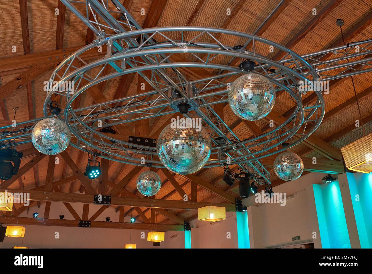 A close-up of disco balls and strobe lights hanging from the ceiling ...