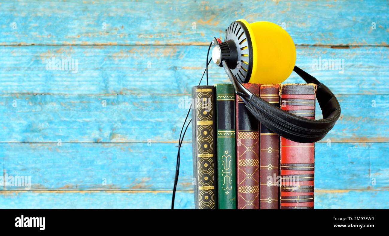 audio book concept with row of books and vintage headphones,blurred ...