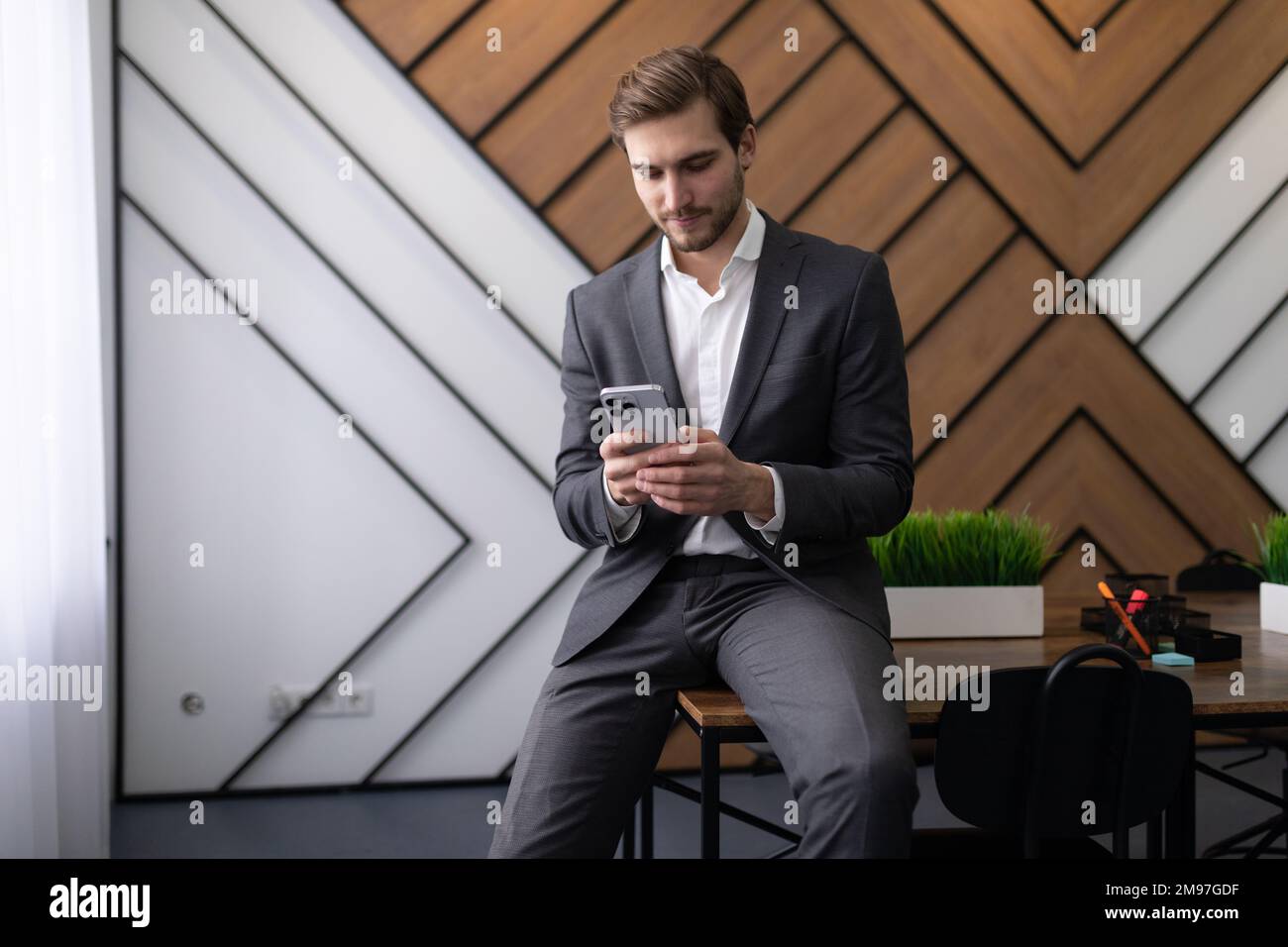 businessman sitting on the desk in the office reading messages on the ...