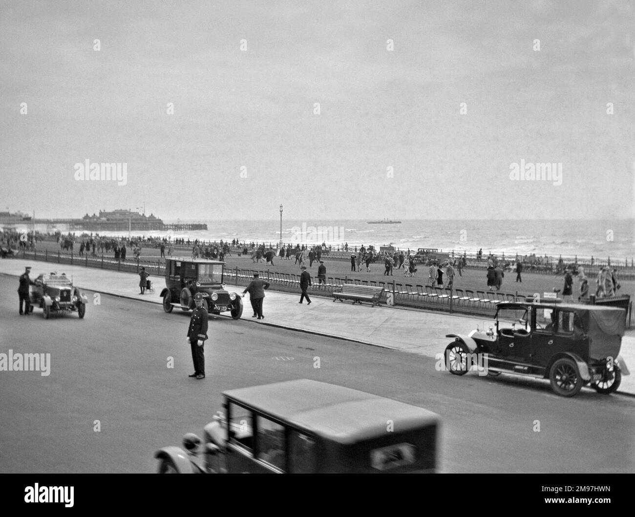 Seaside resort with people on the beach and cars on the road Stock ...